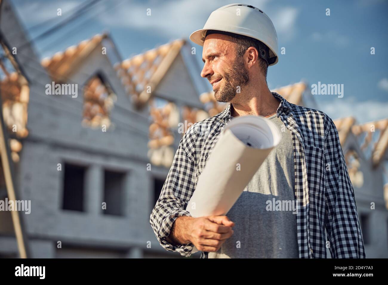 Cheerful architect looking proud while carrying a building plan Stock ...
