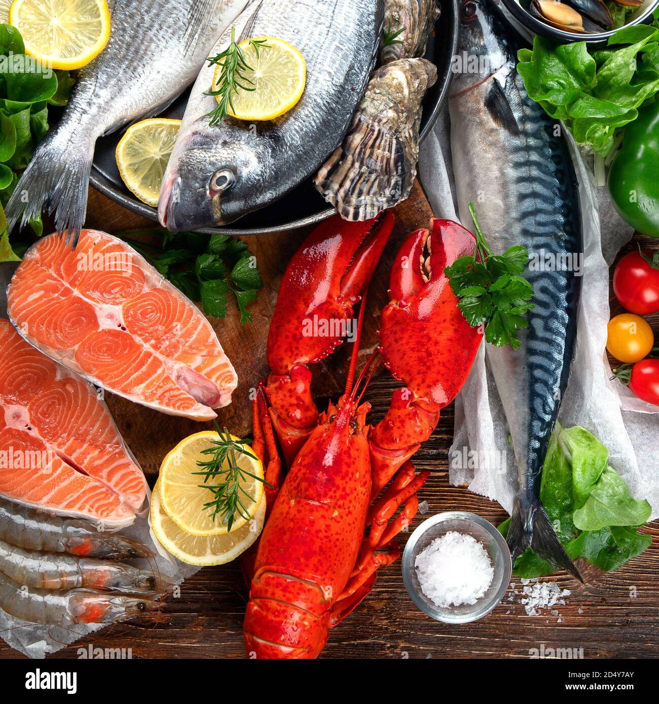 Fresh fish and seafood with herbs, spices and vegetables on rustic ...