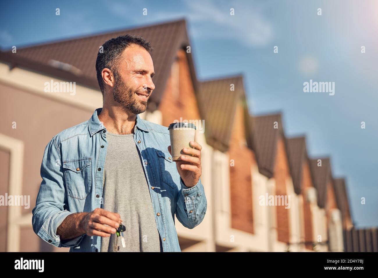 Contented man having morning coffee near his new house Stock Photo - Alamy