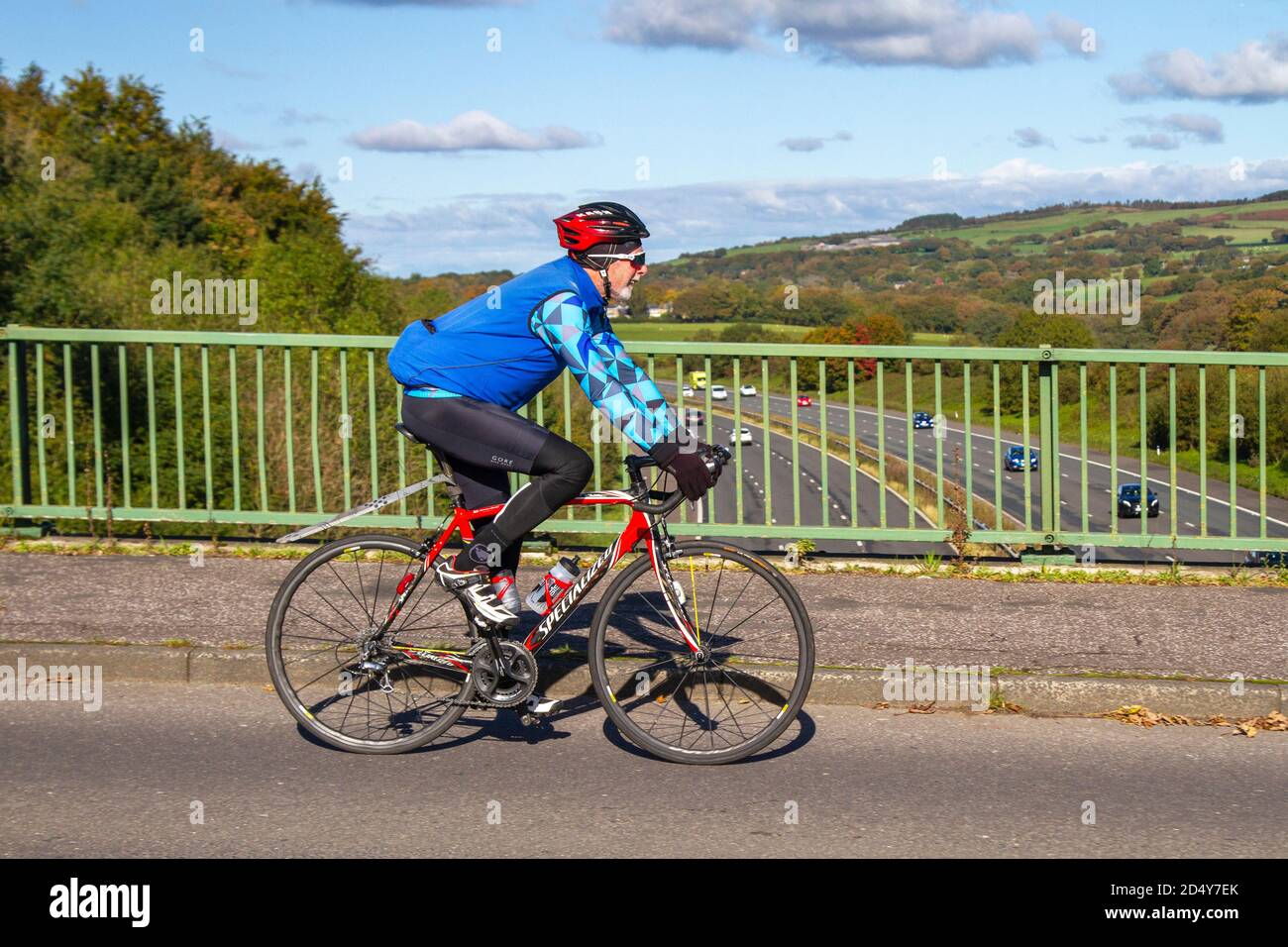 Male cyclist riding re Specilized sports road bike on countryside route ...