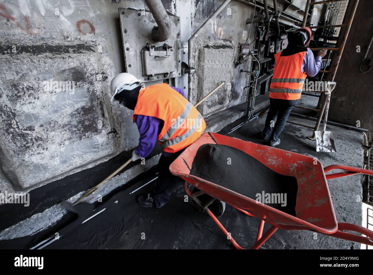 Asian labor with shovel cleanout sewage in the sewer at cement factory ...