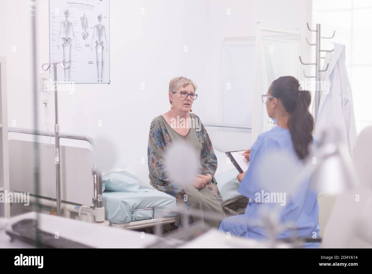 Nurse taking notes during consultation of senior woman in doctor ...