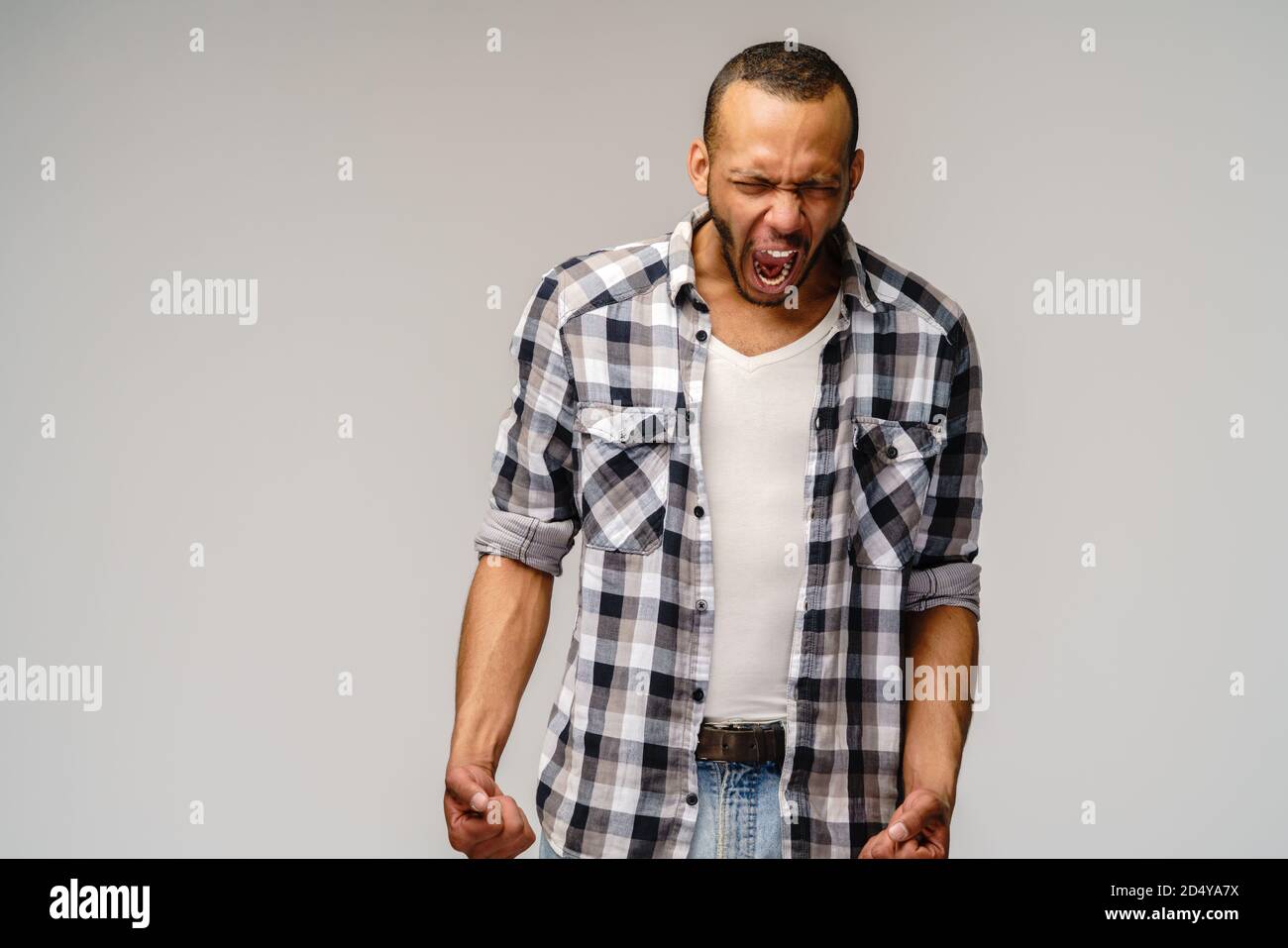 Photo of emotional screaming young african-american man standing over ...