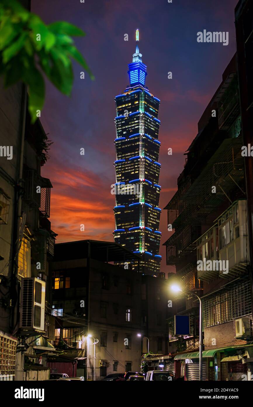 A small alleyway in Taipei at dusk with Taipei 101, the capital city of ...