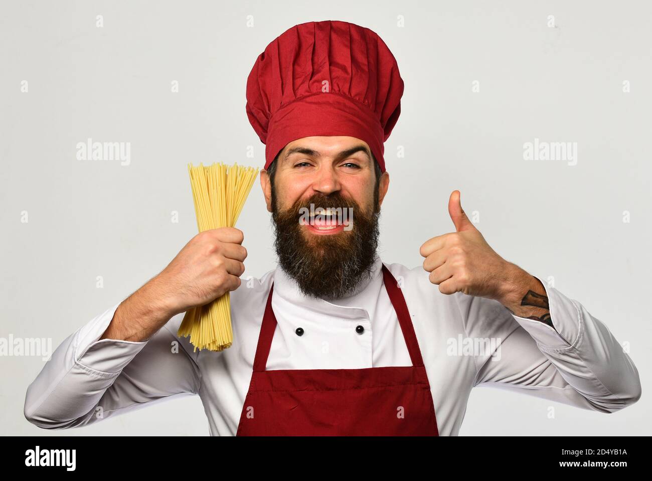 Chef holds bunch of spaghetti in hand. Catering and italian food ...