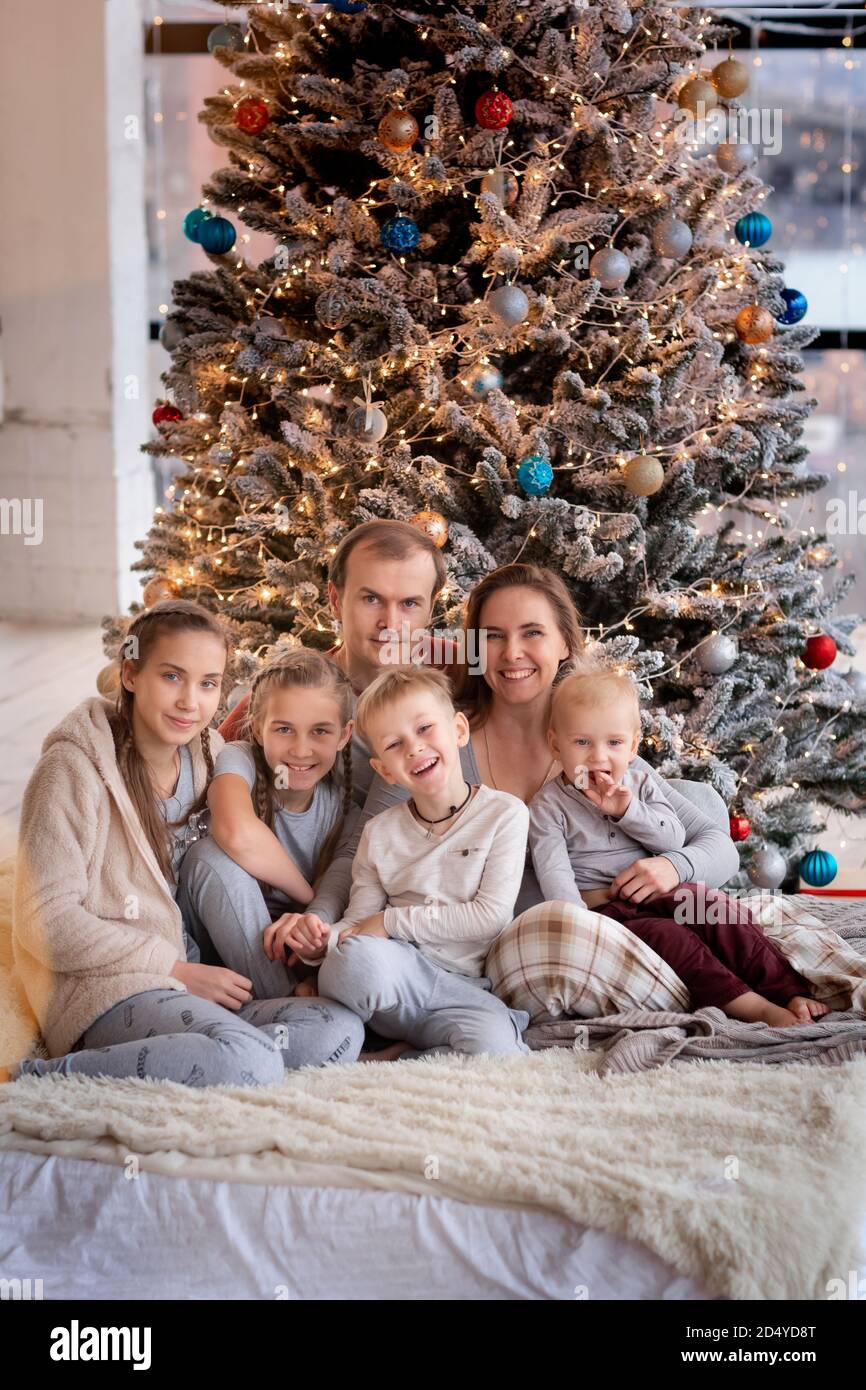 Happy family with kids having fun and opening presents near christmas ...