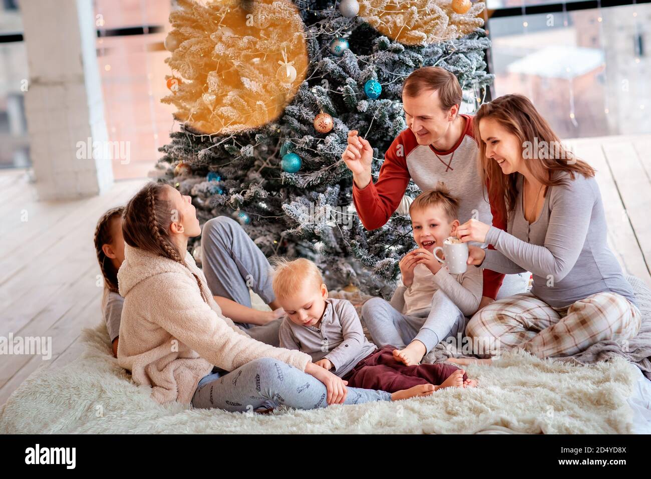 Happy family with kids having fun and opening presents near christmas ...