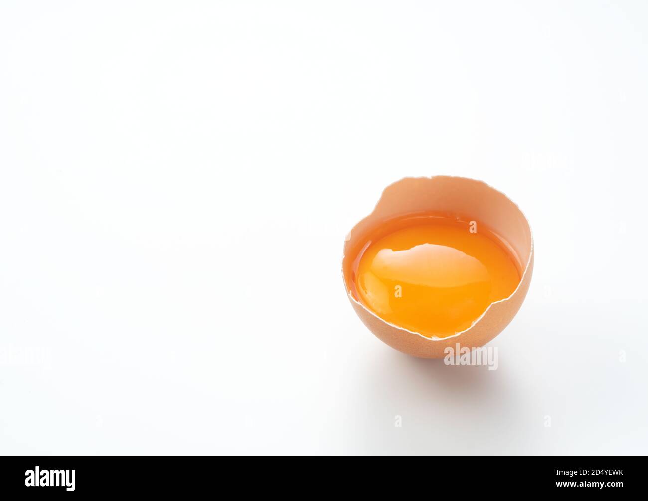 A broken egg placed on a white background with copy space was ...