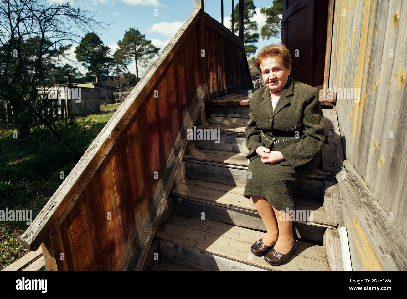 The old woman sitting on the porch of a rural home Stock Photo - Alamy