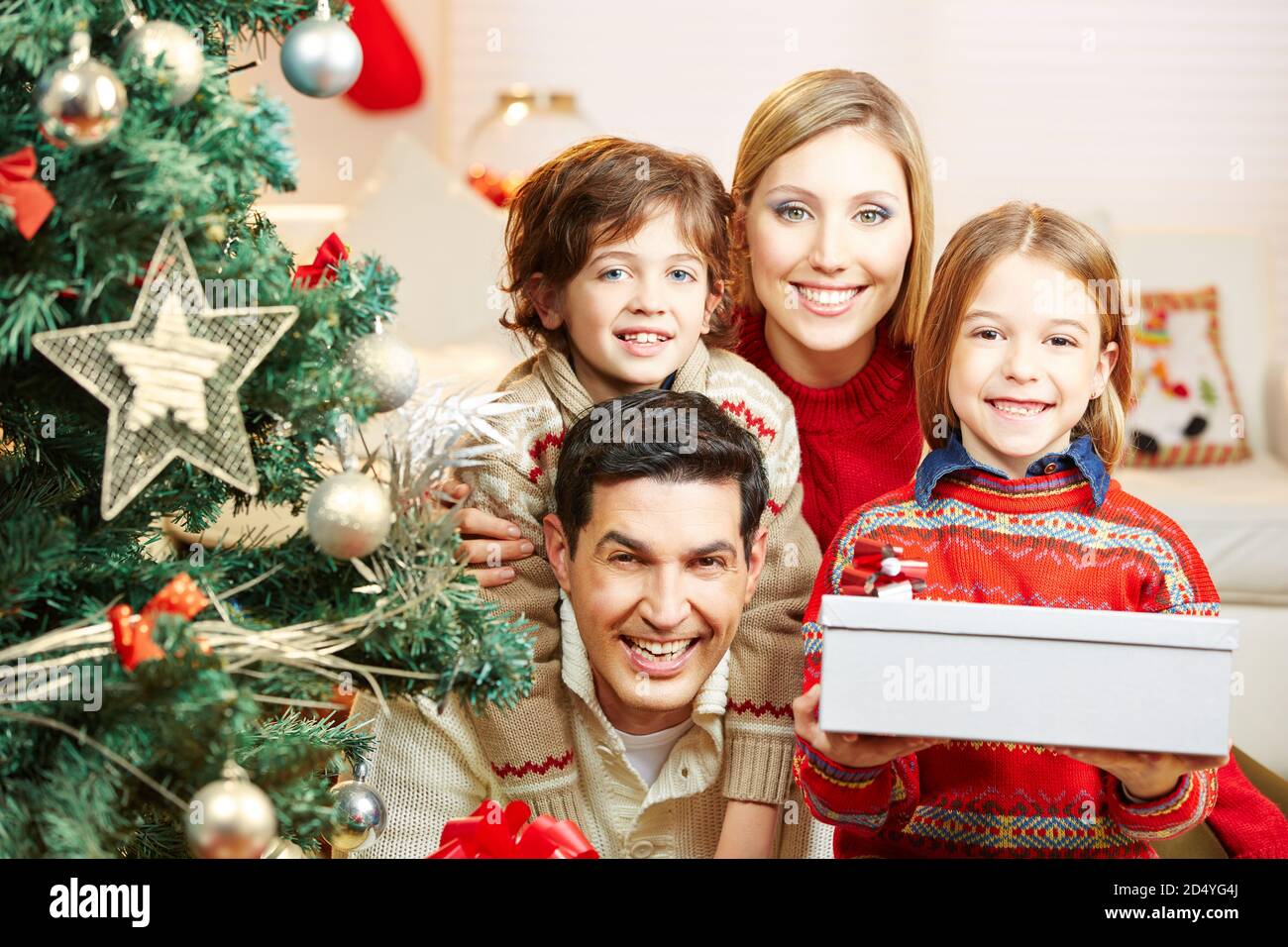 Happy family at Christmas next to the Christmas tree in the living room ...