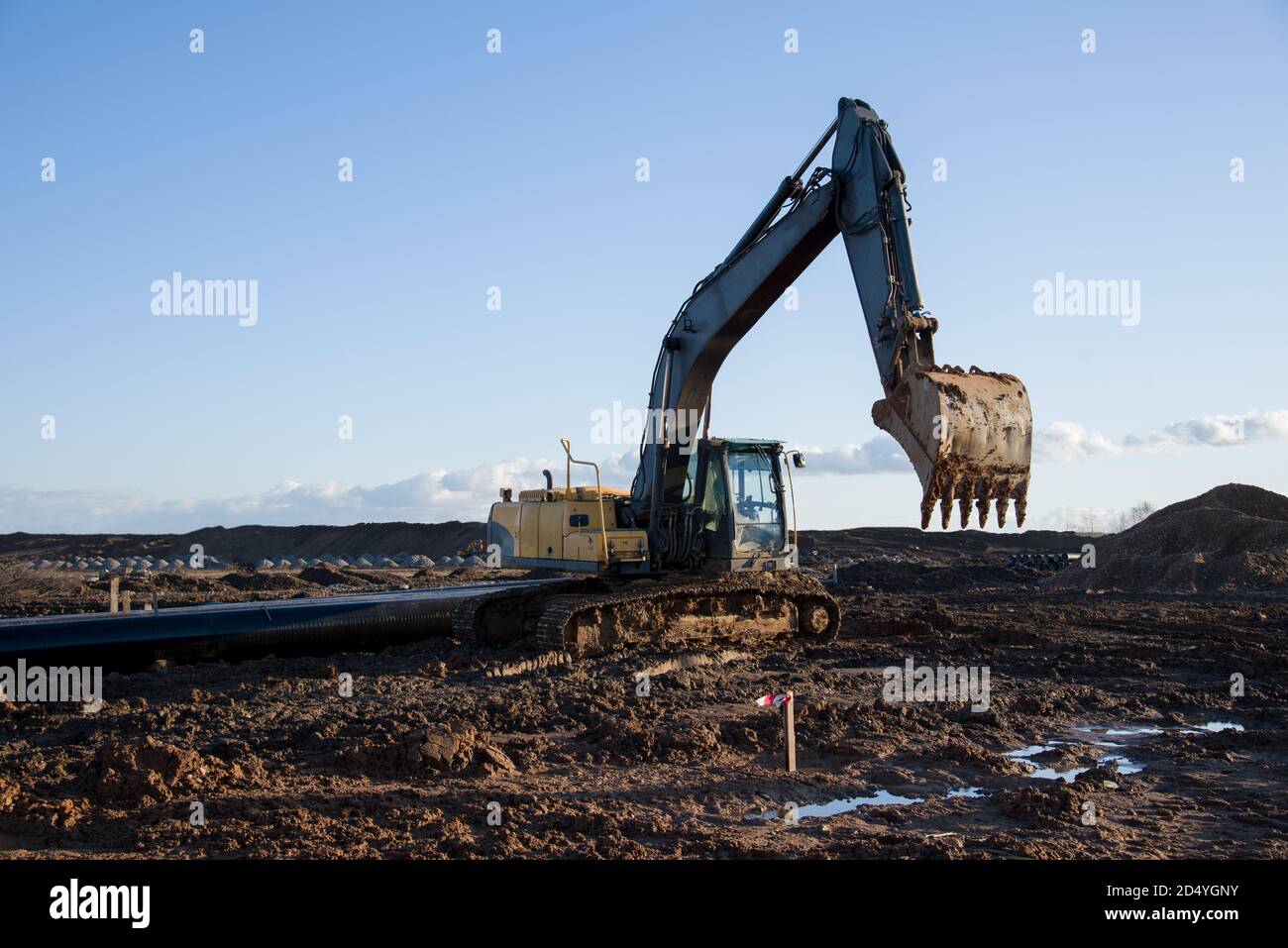 Excavator working at construction site. Backhoe digs ground for the ...