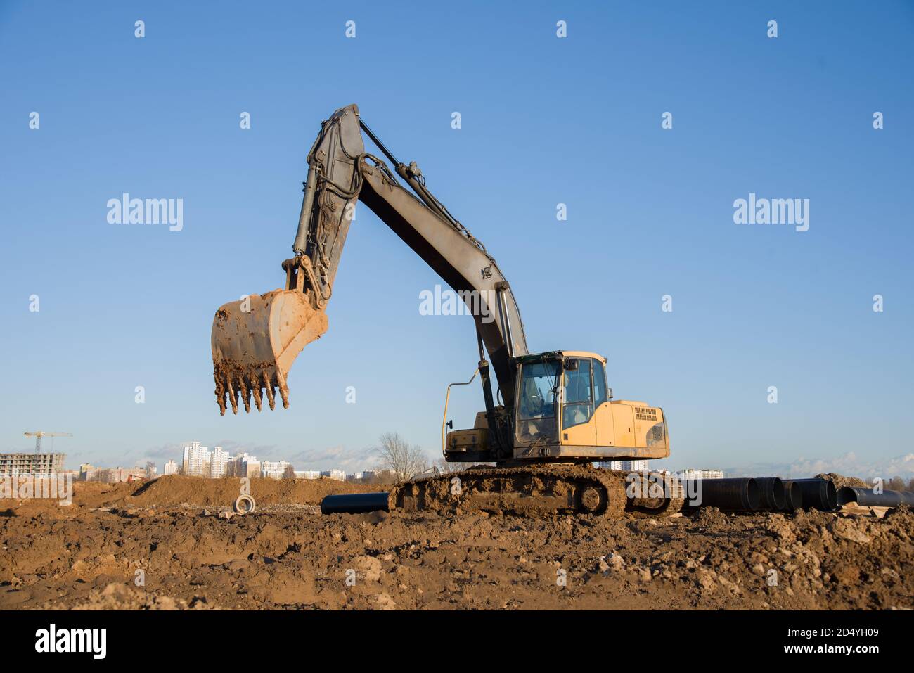 Excavator working at construction site. Backhoe digs ground for the ...