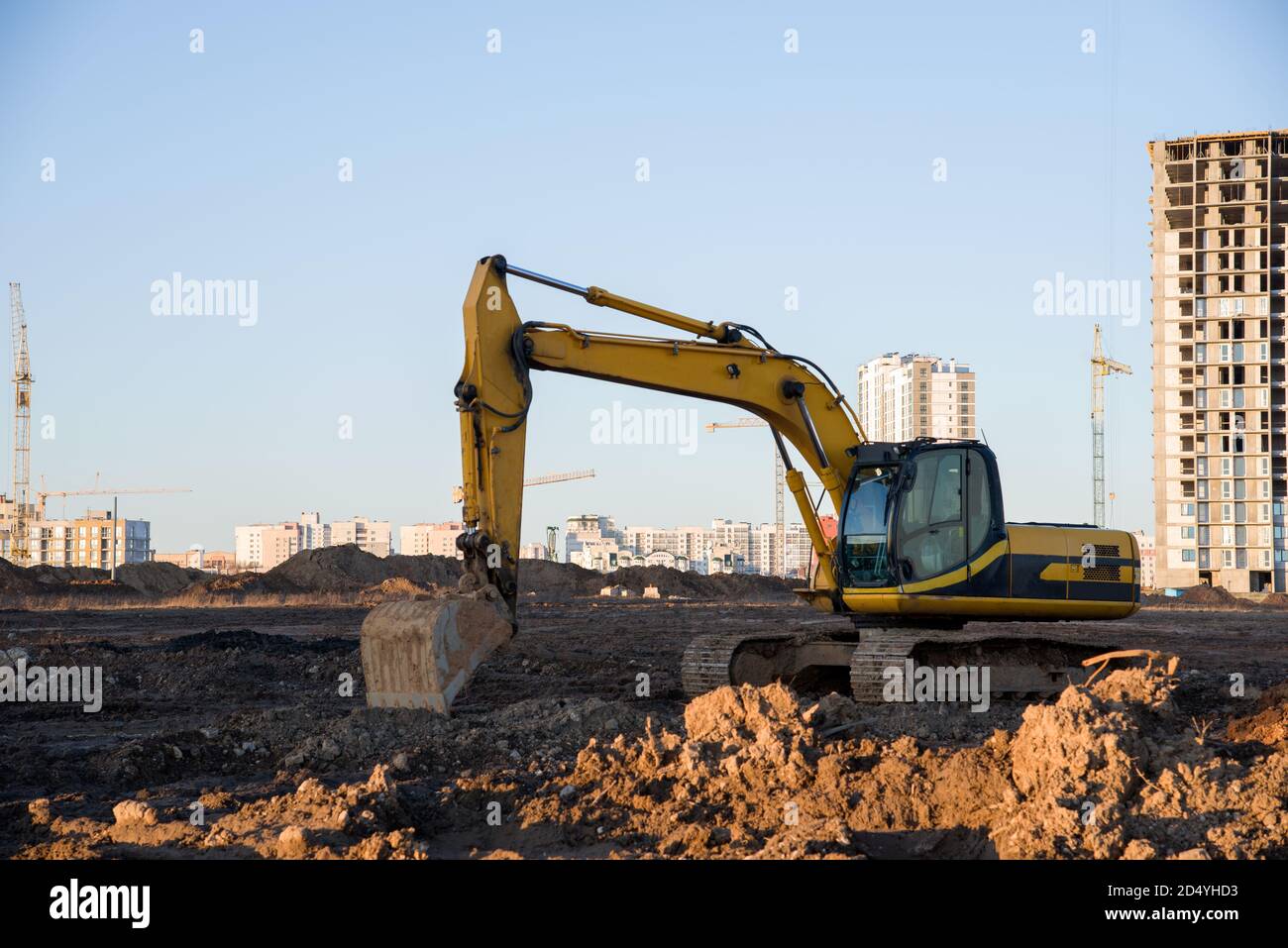 Excavator working at construction site. Backhoe digs ground for the ...