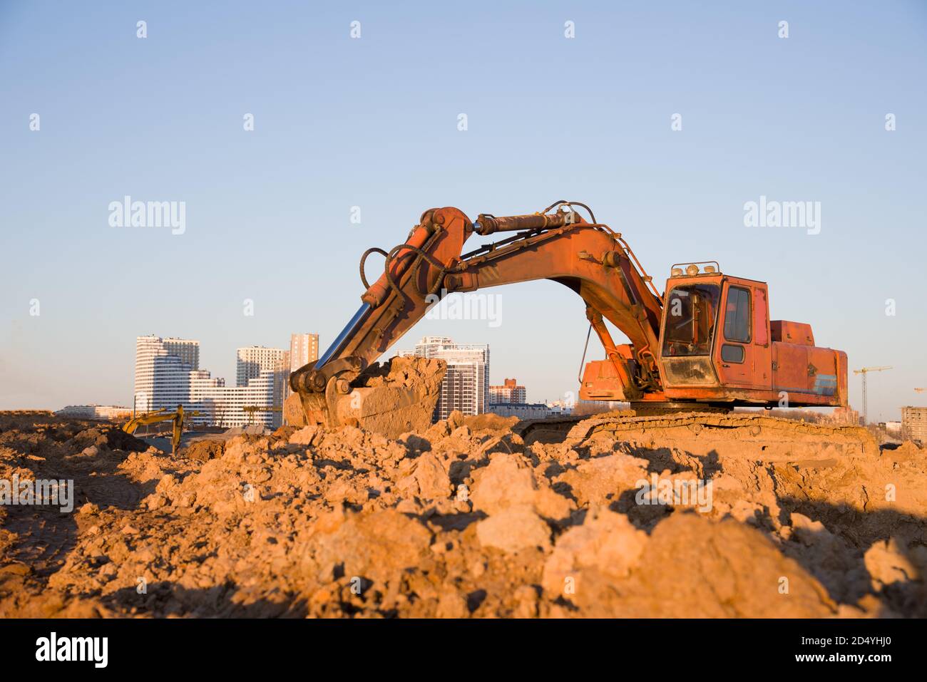 Excavator working at construction site. Backhoe digs ground for the ...