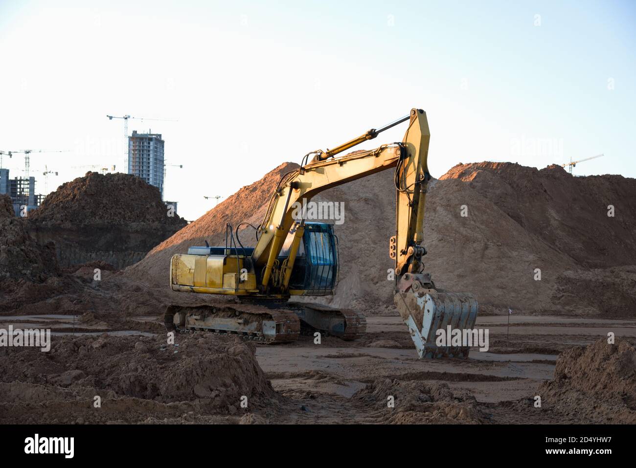 Excavator working at construction site. Backhoe digs ground for the ...