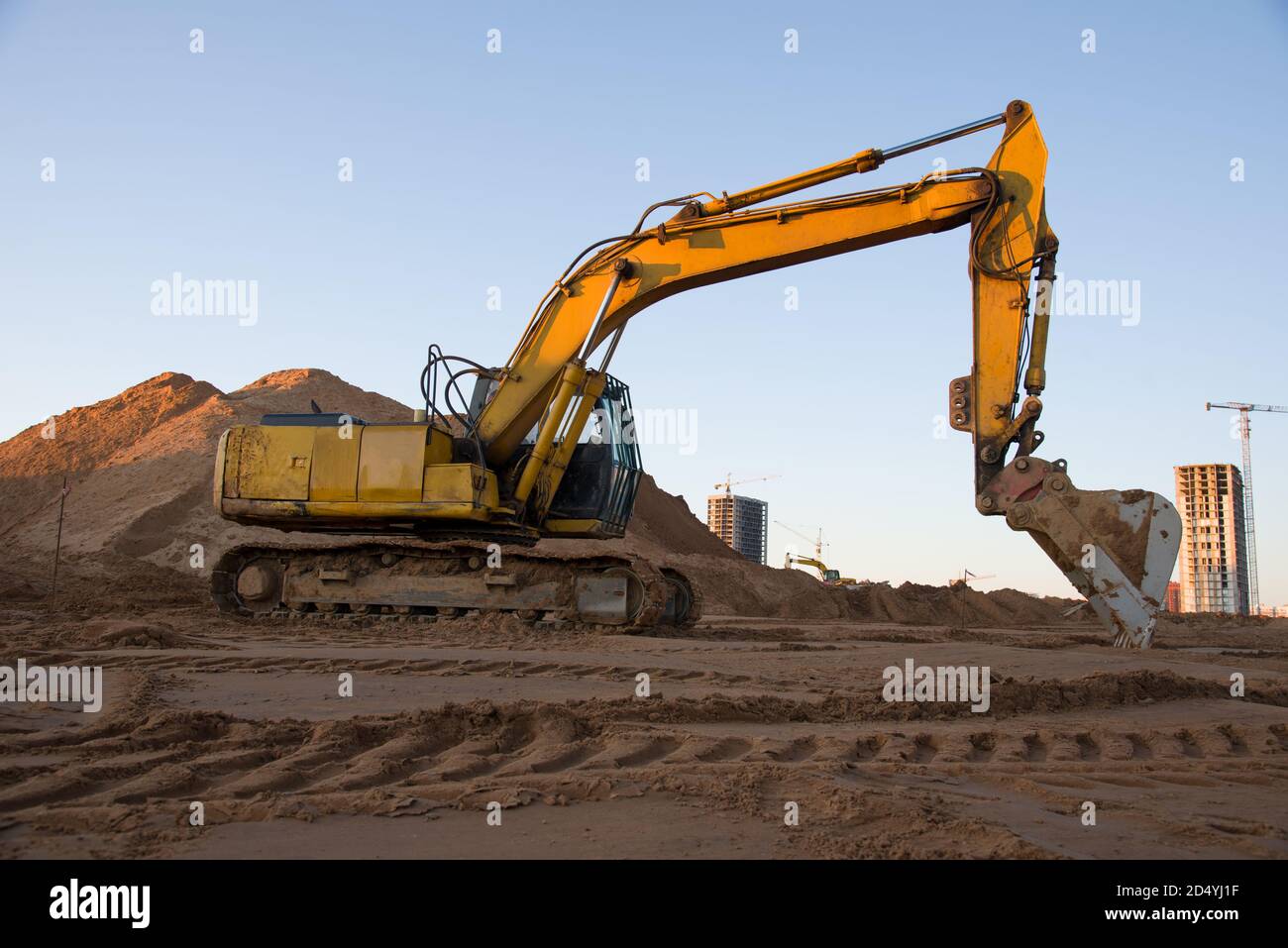 Excavator working at construction site. Backhoe digs ground for the ...