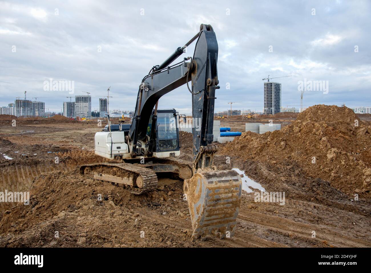 Excavator at earthworks on construction site. Backhoe loader digs a pit ...