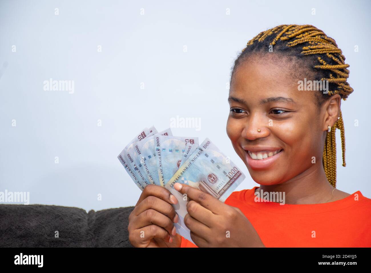 black lady holding some cash close to her face, smiling Stock Photo - Alamy