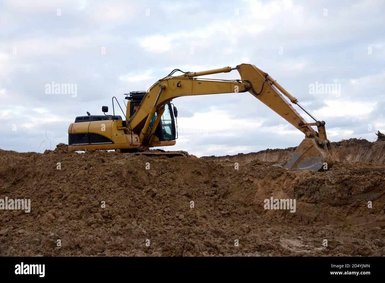 Excavator at earthworks on construction site. Backhoe loader digs a pit ...