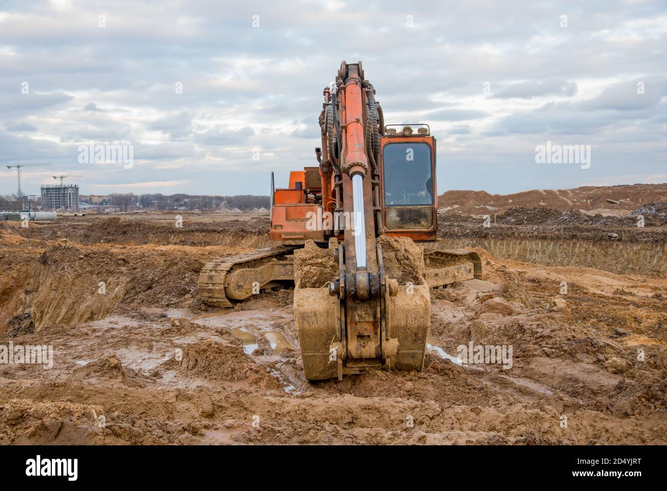 Excavator at earthworks on construction site. Backhoe loader digs a pit ...