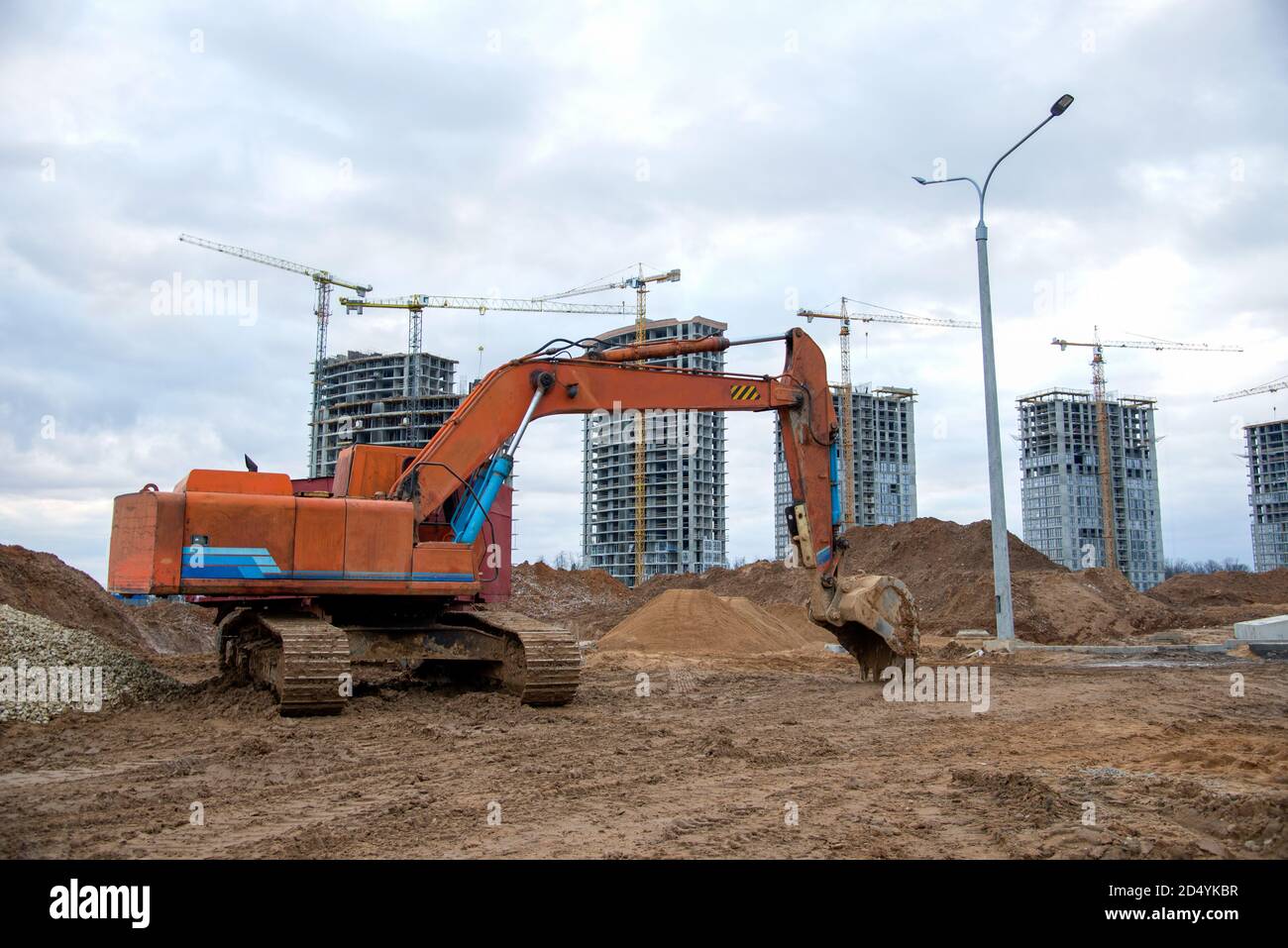 Excavator working at construction site. Backhoe digs ground for the ...