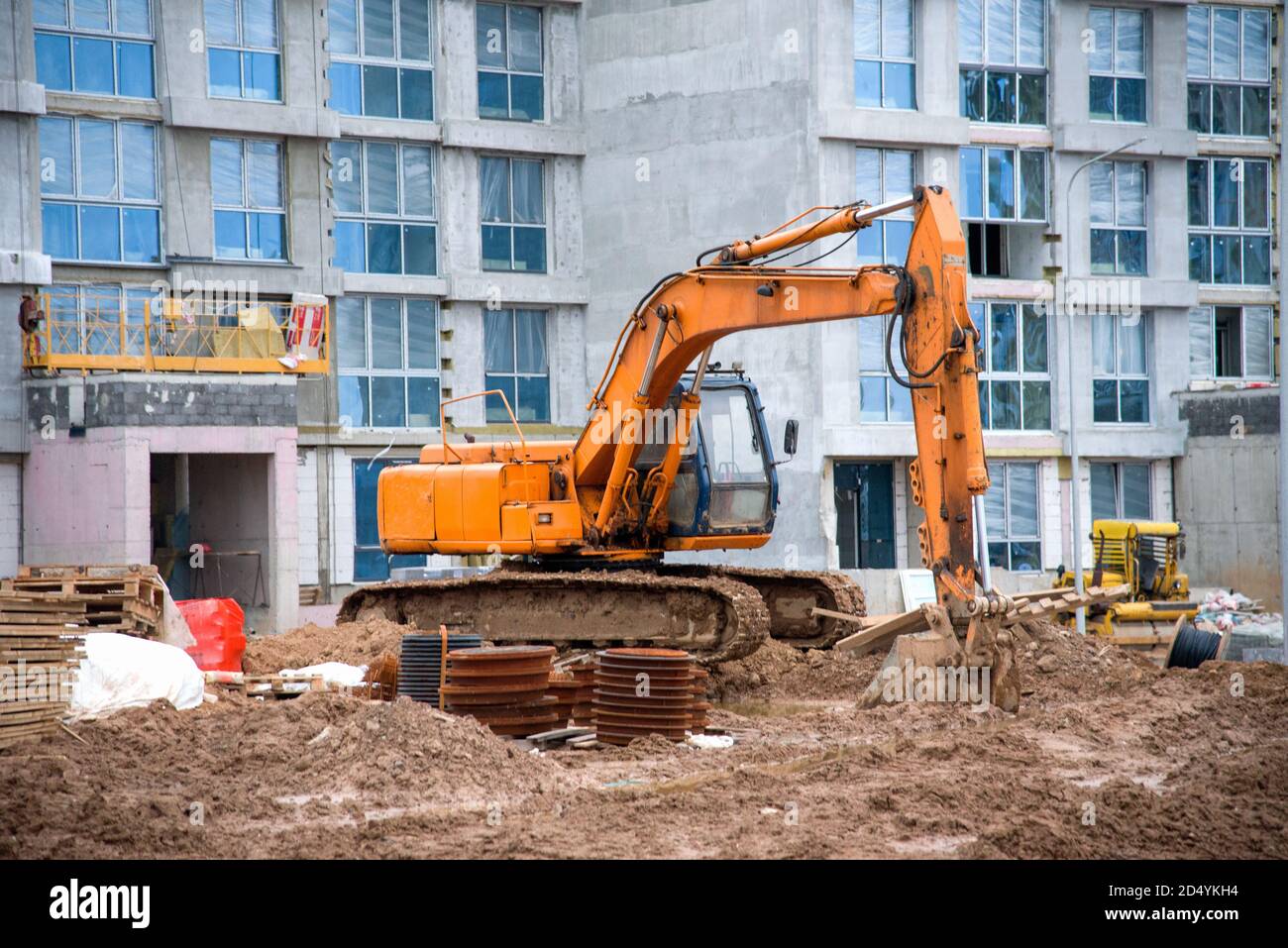 Excavator working at construction site. Backhoe digs ground for the ...