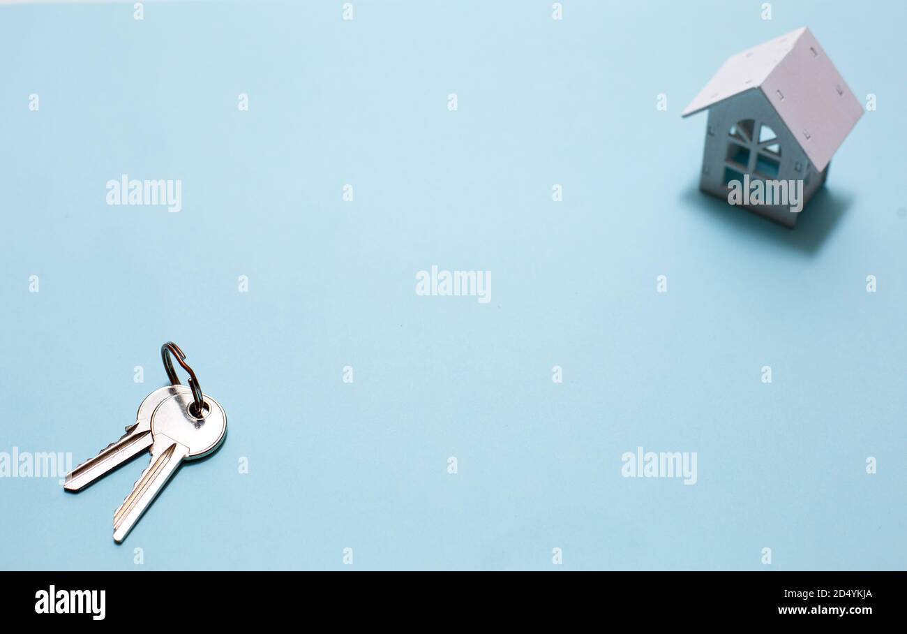 White wooden house symbol and keys on a blue background. Cottage ...