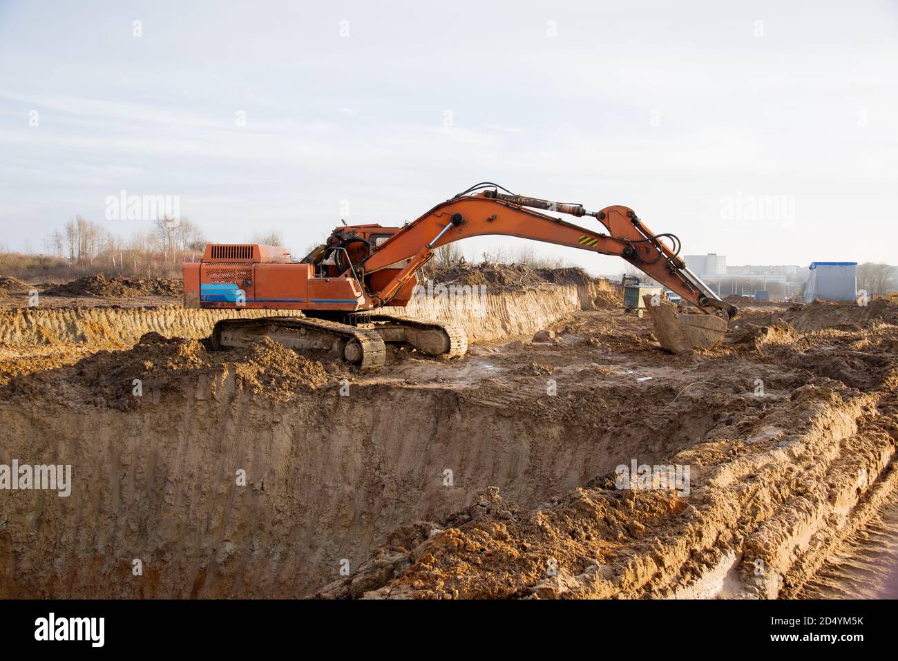 Excavator working at construction site. Backhoe digs ground for the ...
