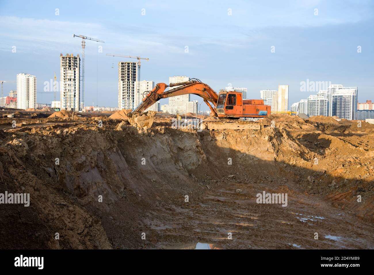 Excavator at earthworks on construction site. Backhoe loader digs a pit ...