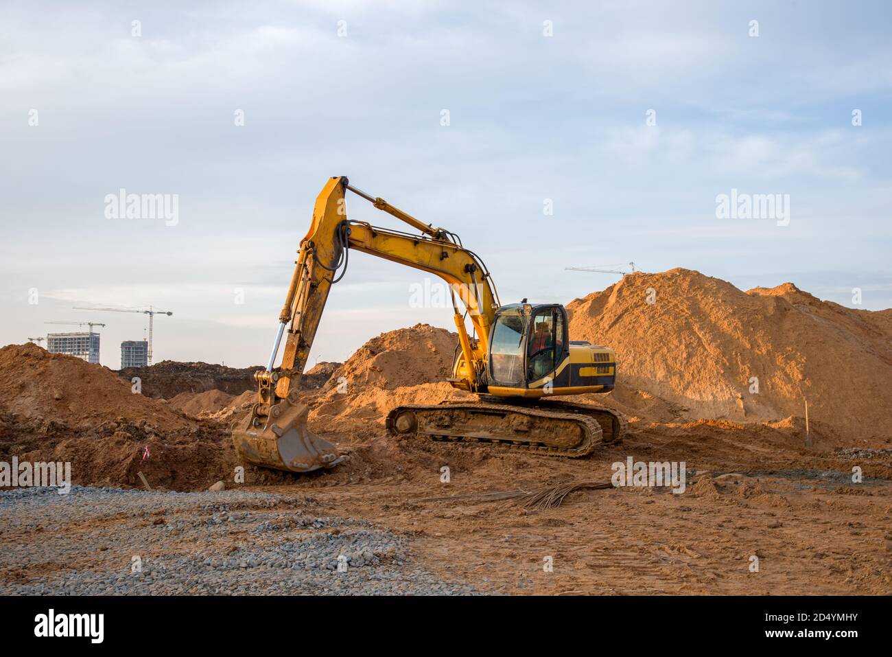 Excavator working at construction site. Backhoe digs ground for the ...