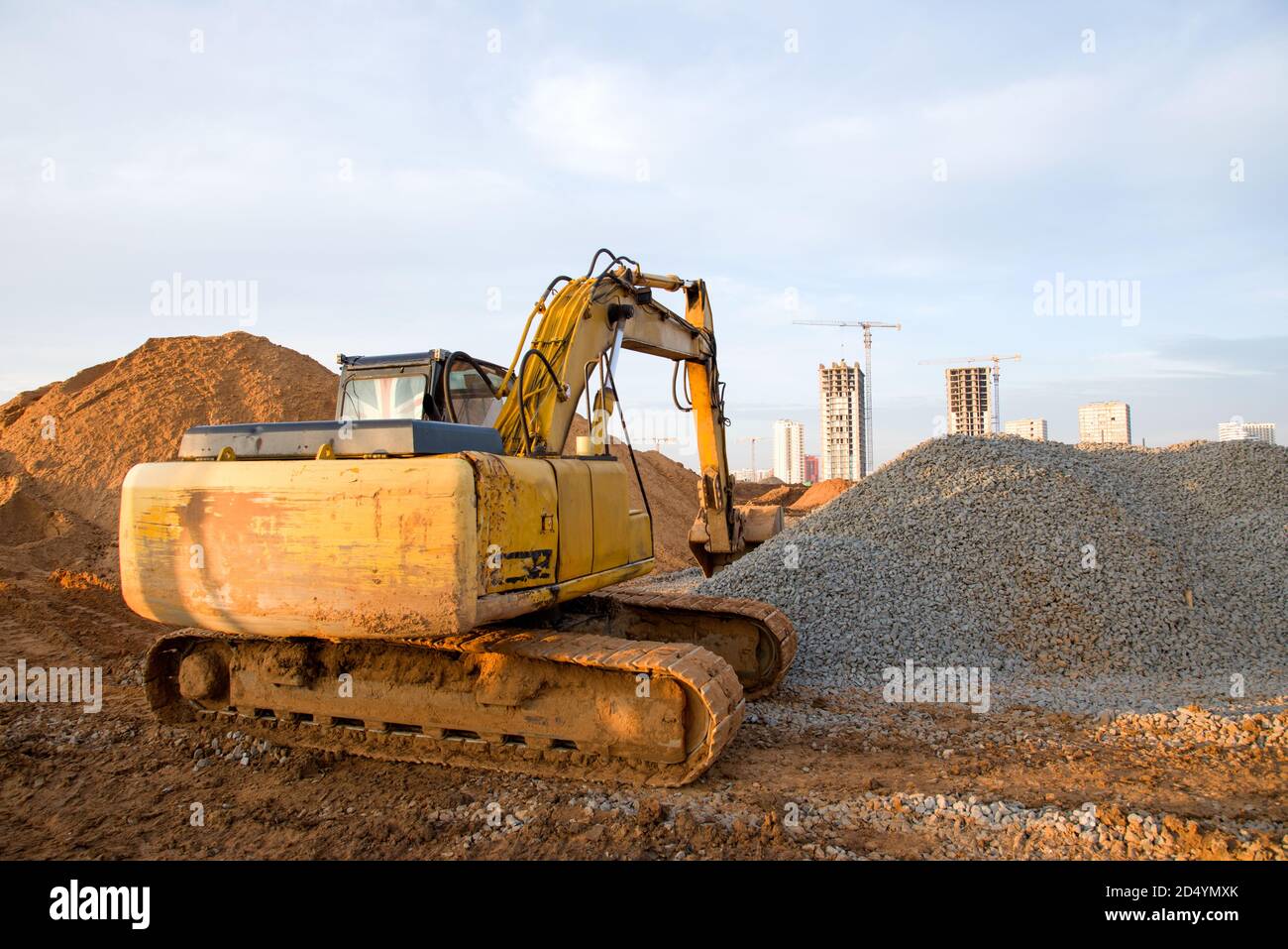 Excavator at earthworks on construction site. Backhoe loader digs a pit ...