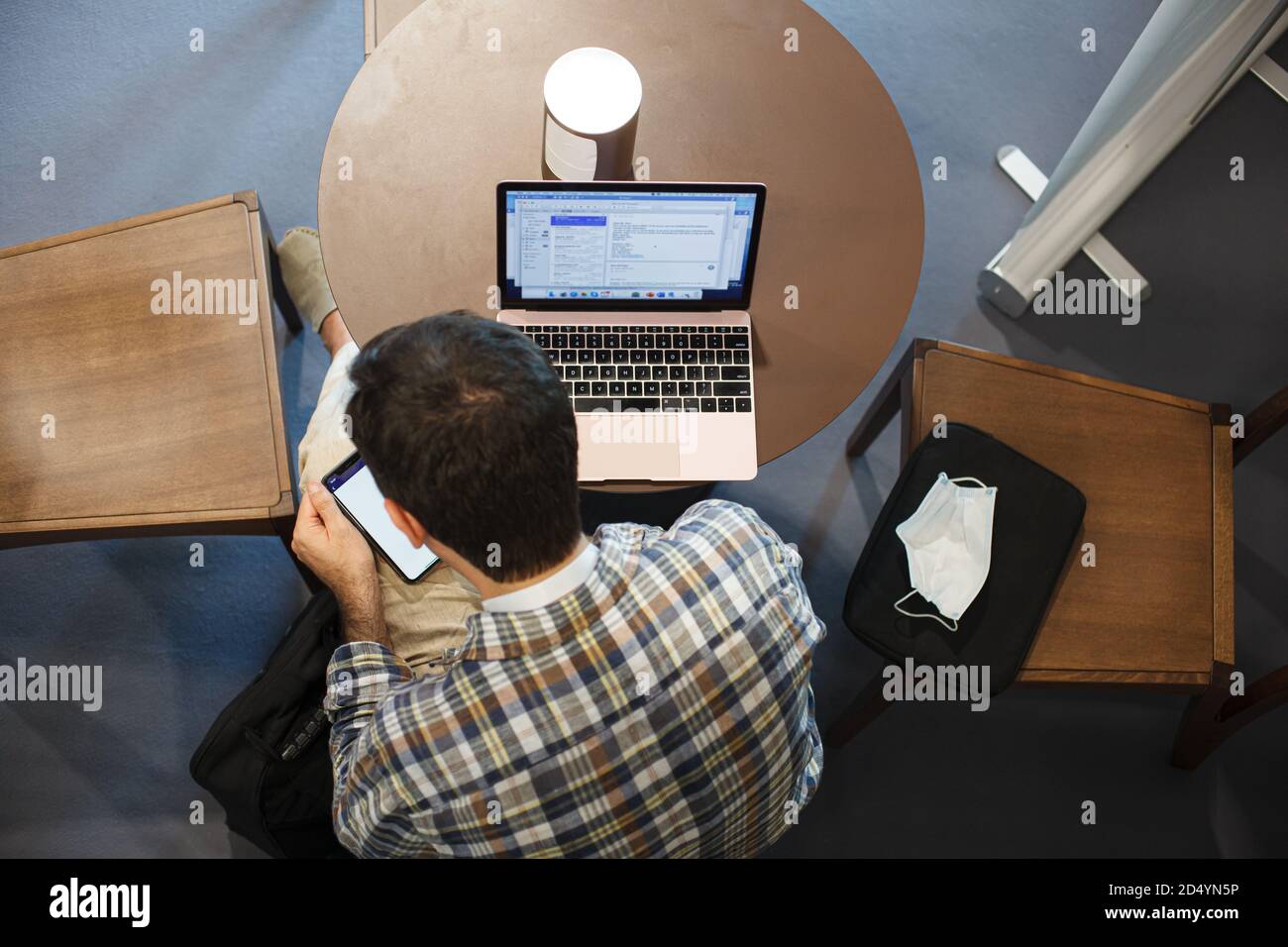Top view of a man sitting at the table working with his notebook Stock ...