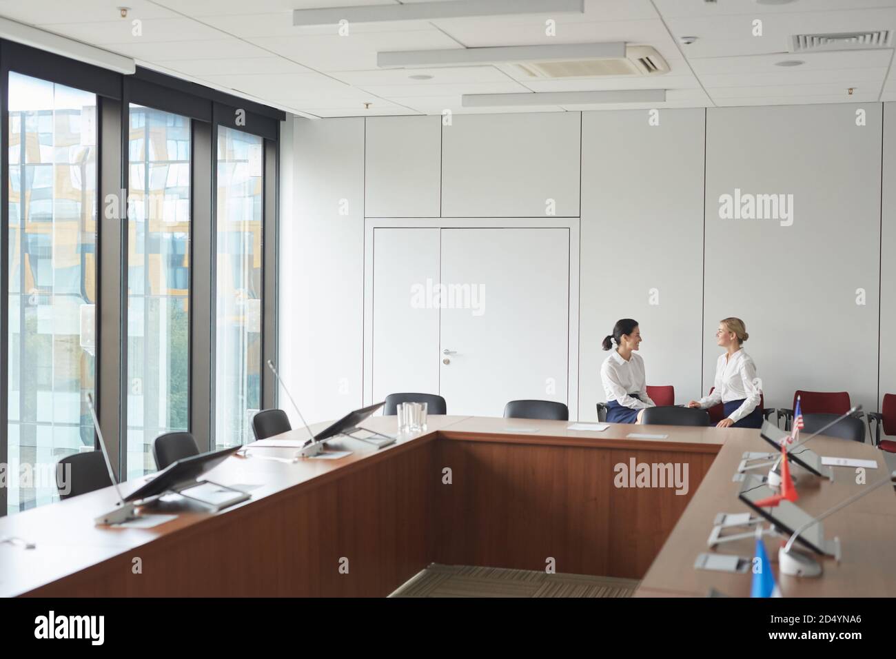 Wide angle shot of classic conference room interior with two female ...