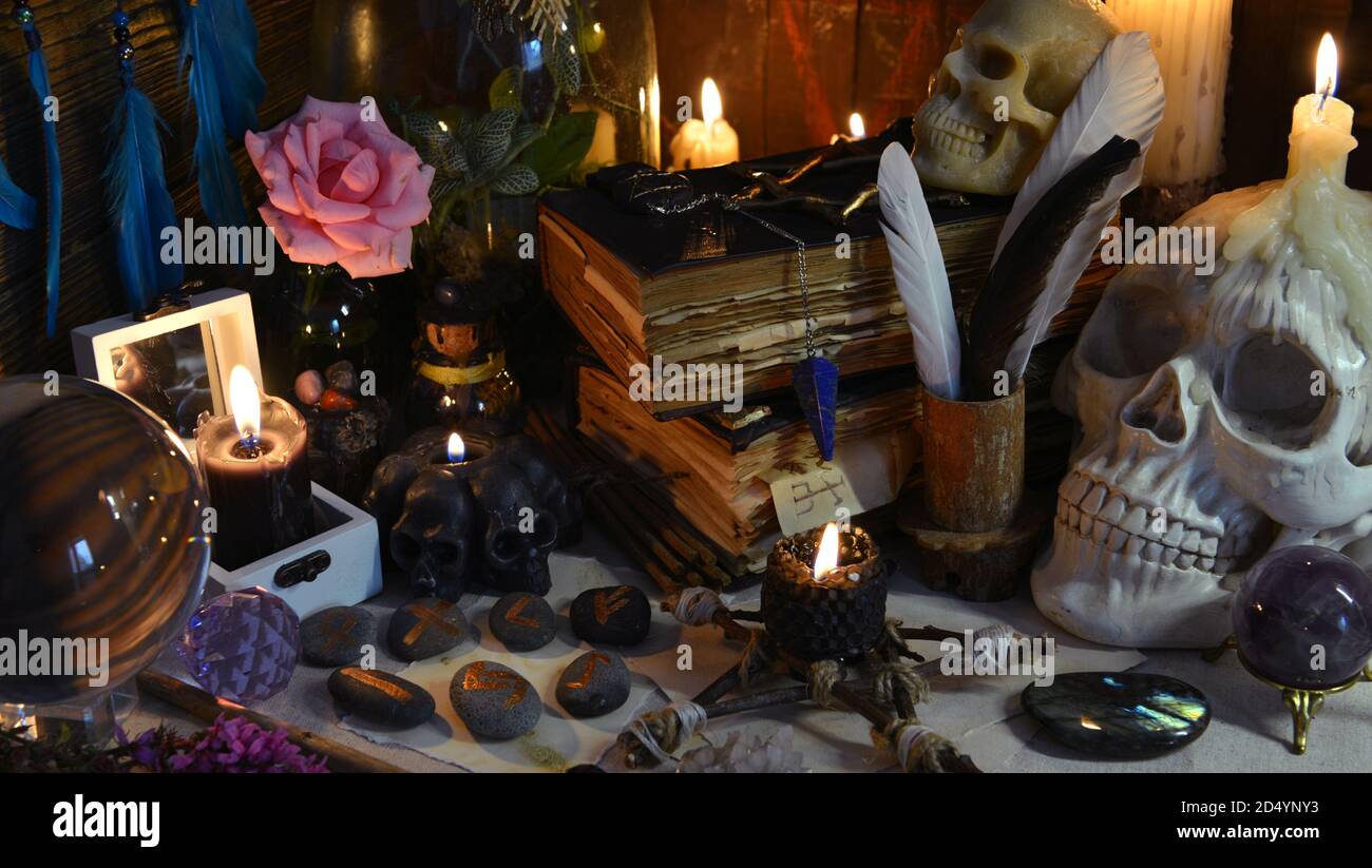 Mysterious still life with evil skull, spell book, runes and black ...
