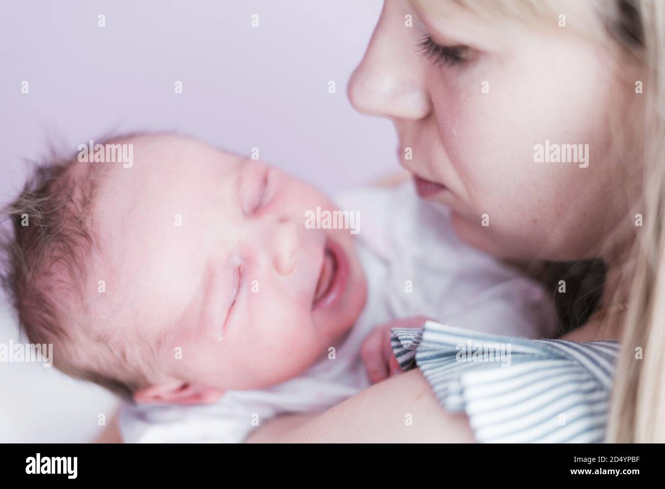 Lifestyle portrait of a young mother and her newborn, three weeks old ...