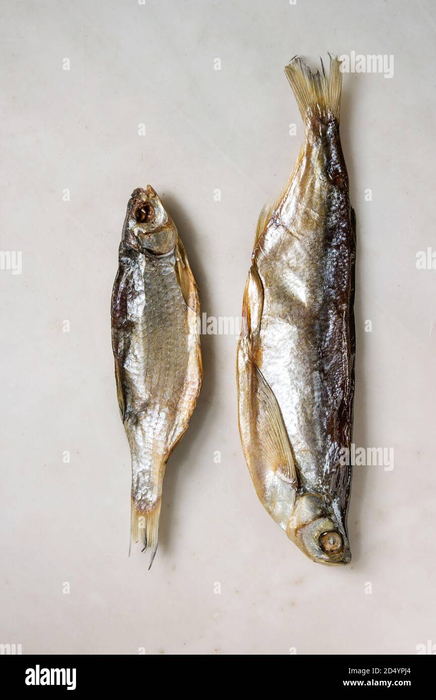 Dried fish or stockfish over white marble background. Flat lay, space ...