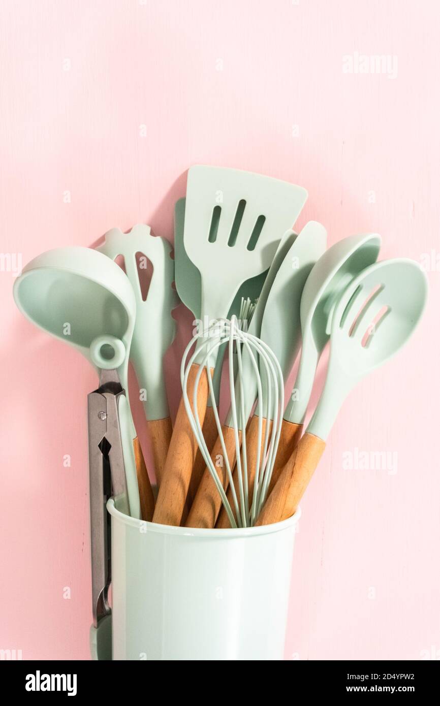 Flat lay. New blue silicone kitchen utensils with wooden handles on a ...