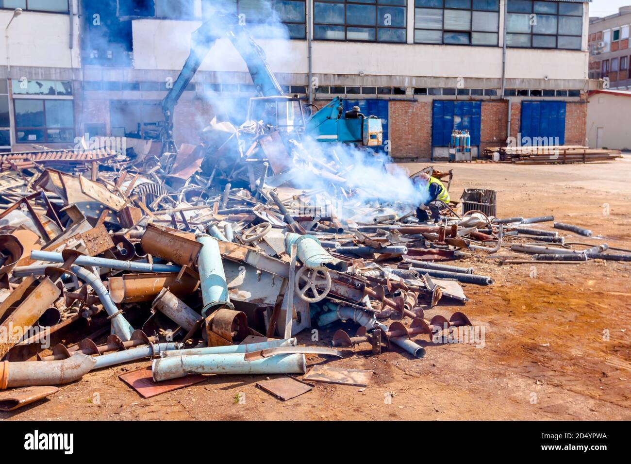 Worker is cutting waste metal with gas by mixing oxygen and acetylene ...