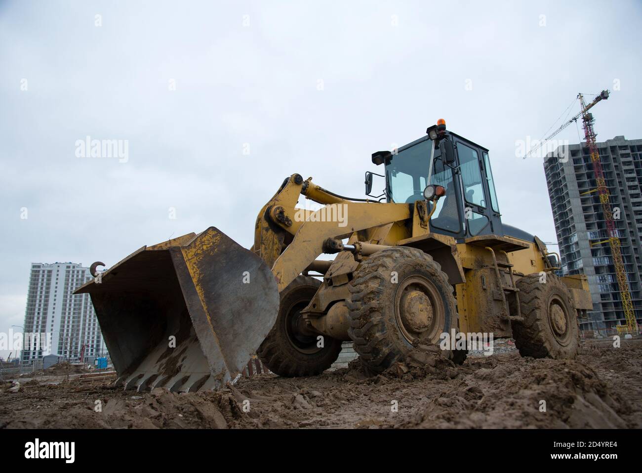 Front-end loader working at construction site. Earth-moving heavy ...