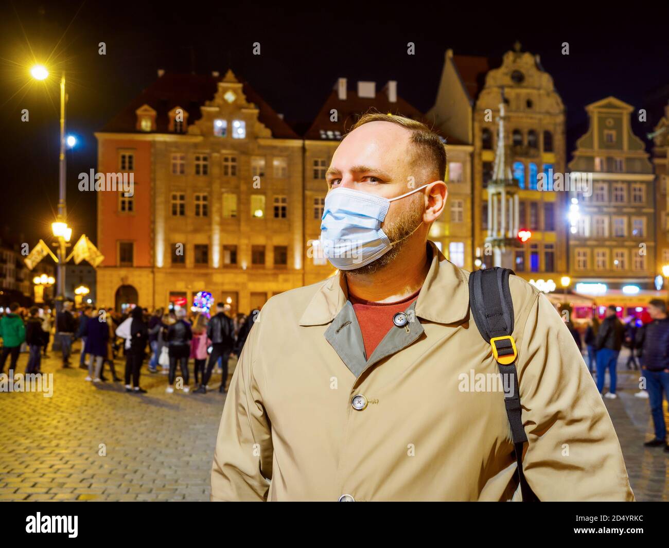 Adult man wearing mask walking in a night european city. Mask is a ...