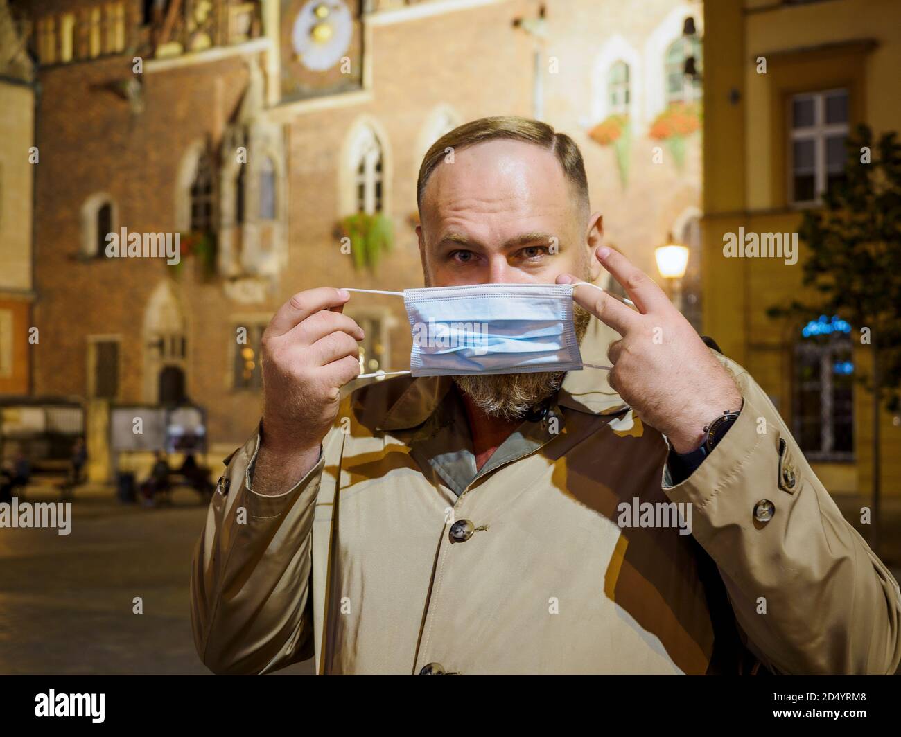 Adult man wearing mask walking in a night european city. Mask is a ...