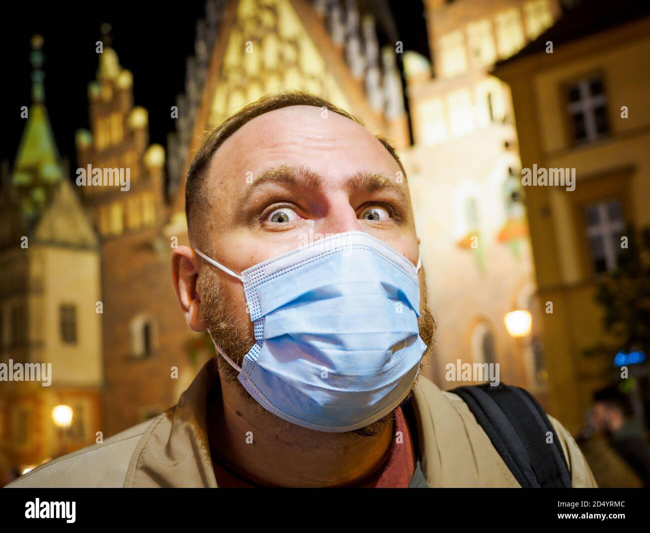 Adult man wearing mask walking in a night european city. Mask is a ...