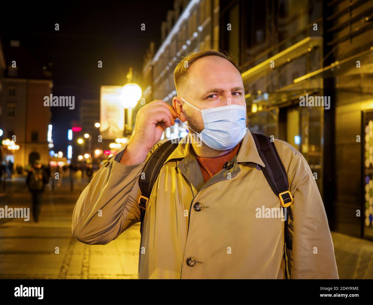 Adult man wearing mask walking in a night european city. Mask is a ...
