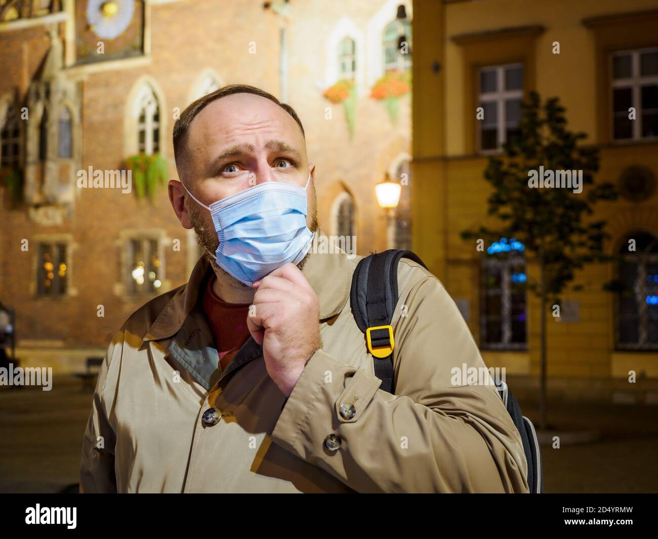 Adult man wearing mask walking in a night european city. Mask is a ...