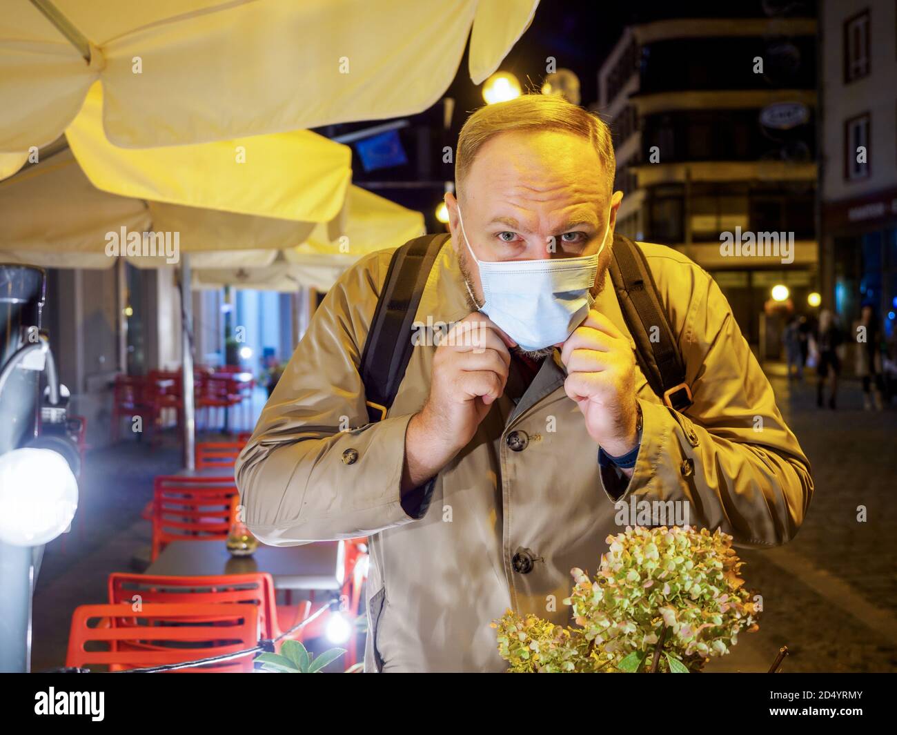 Adult man wearing mask walking in a night european city. Mask is a ...