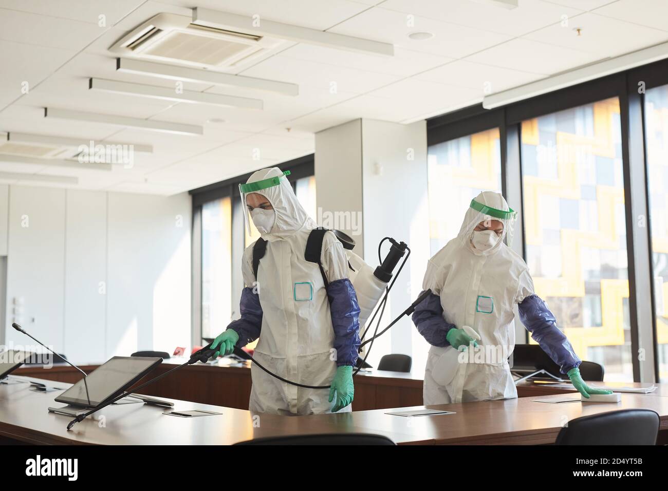 Wide angle portrait of two sanitation workers wearing hazmat suits ...