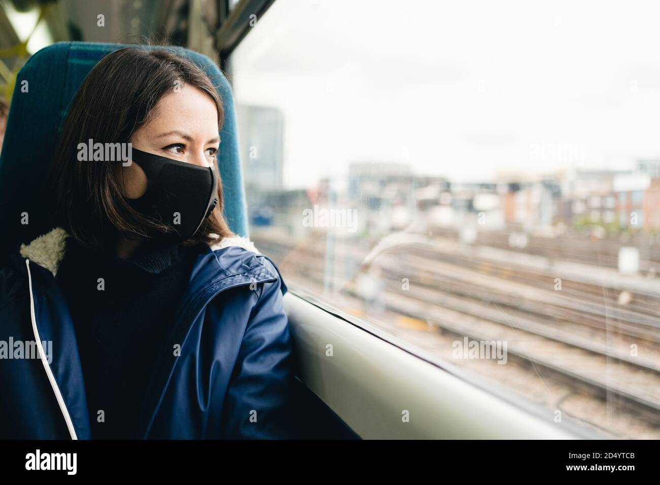 Woman in a train wearing a face mask Stock Photo - Alamy
