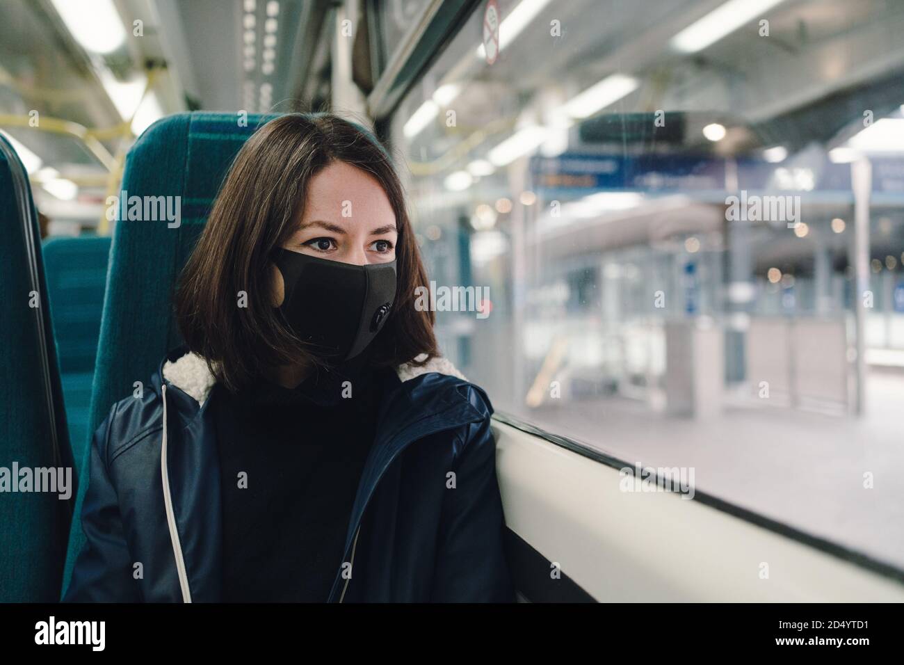 Woman in a train wearing a face mask Stock Photo - Alamy