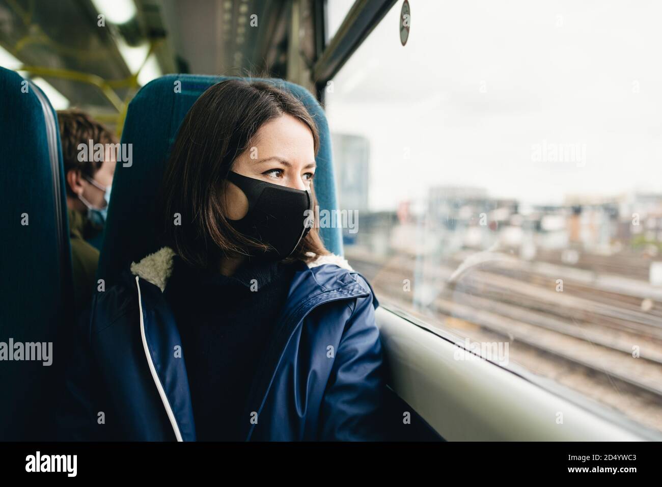 Woman in a train wearing a face mask Stock Photo - Alamy