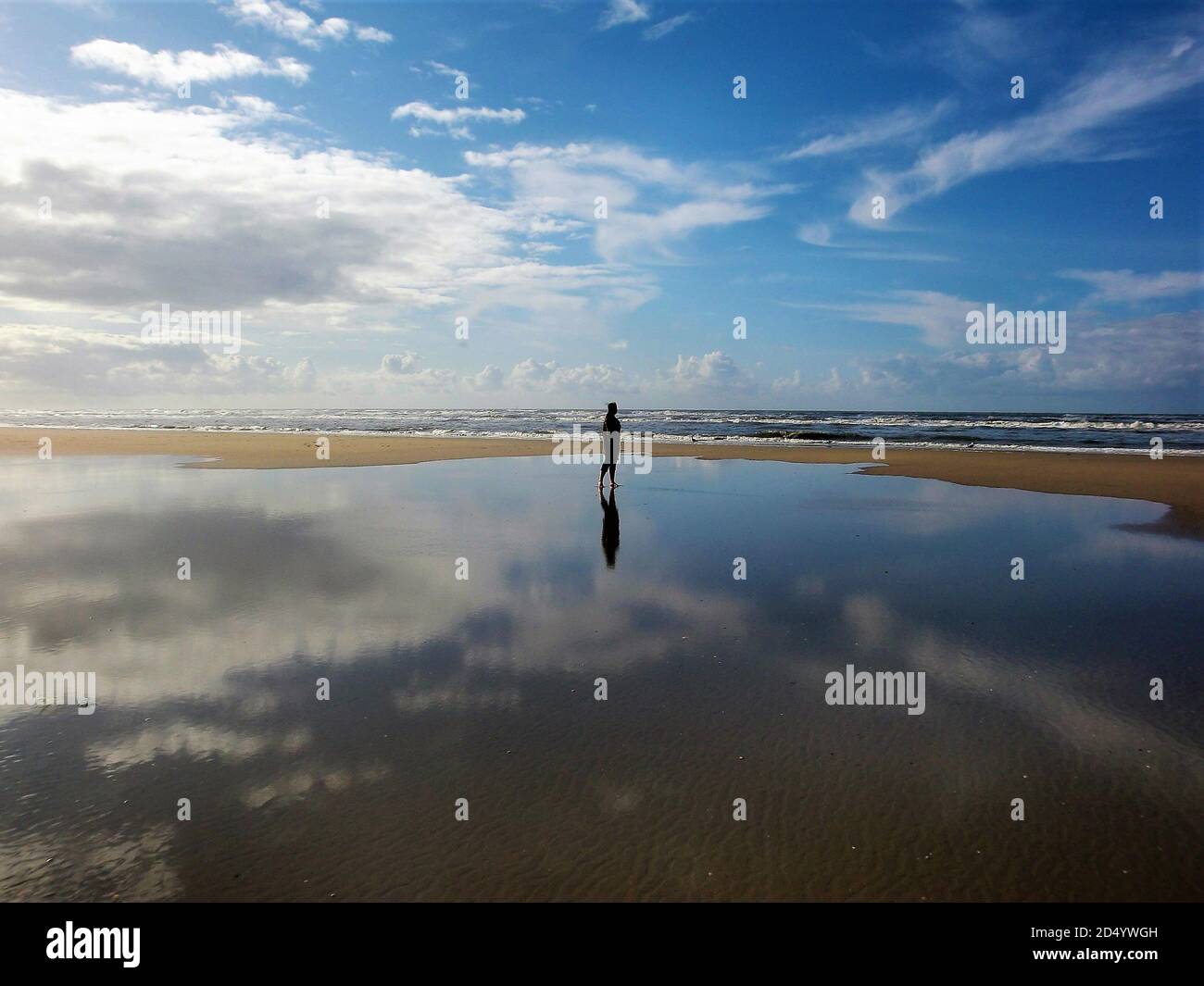 Person standing in the water at the german coast. North sea island of ...